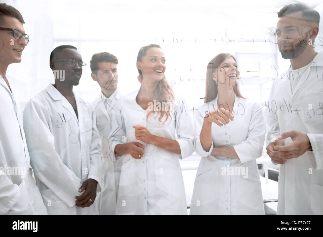 group of researchers are standing near the blackboard with formu Stock ...