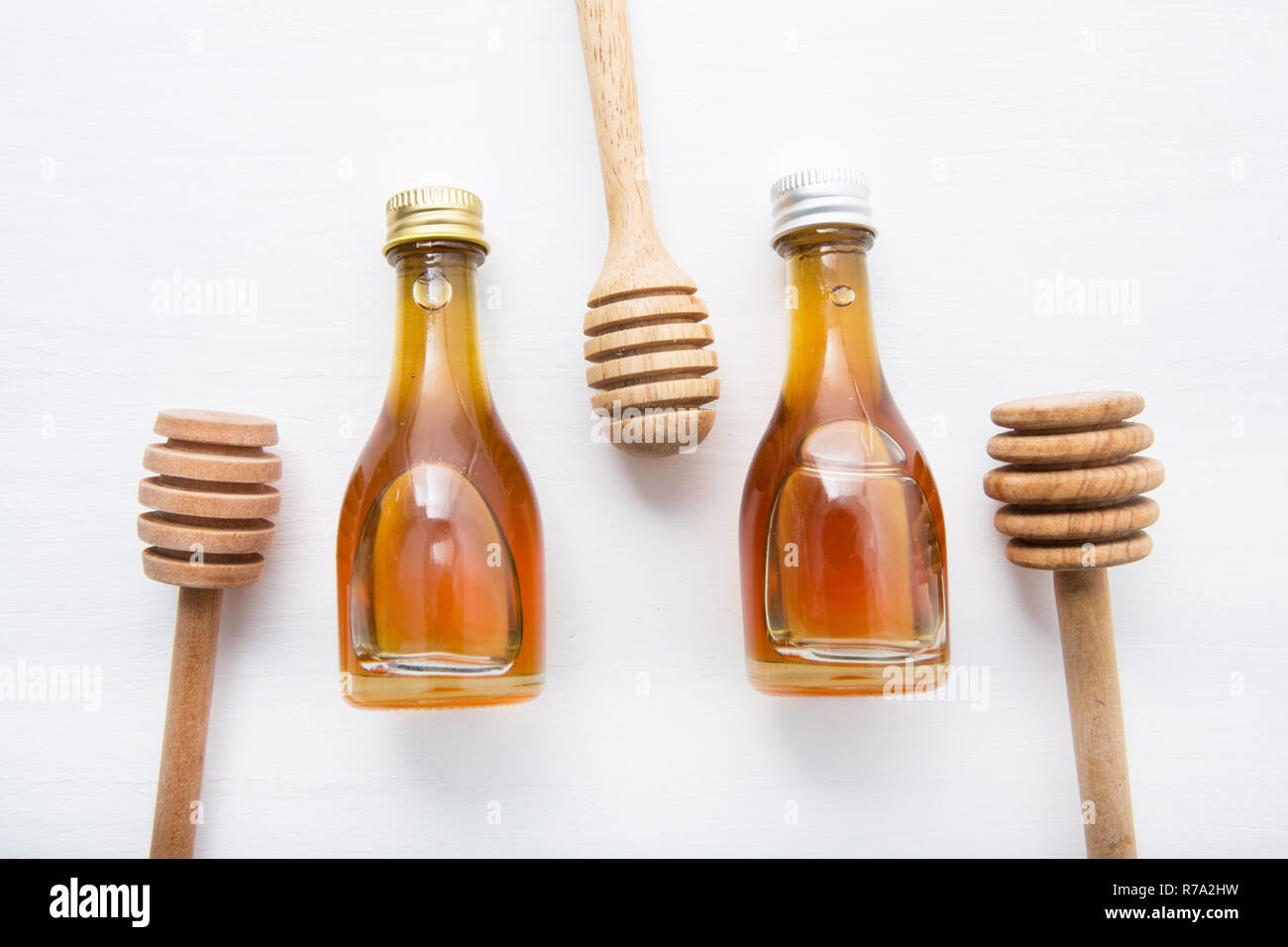 wooden dipper and little honey bottle on white wooden background Stock ...