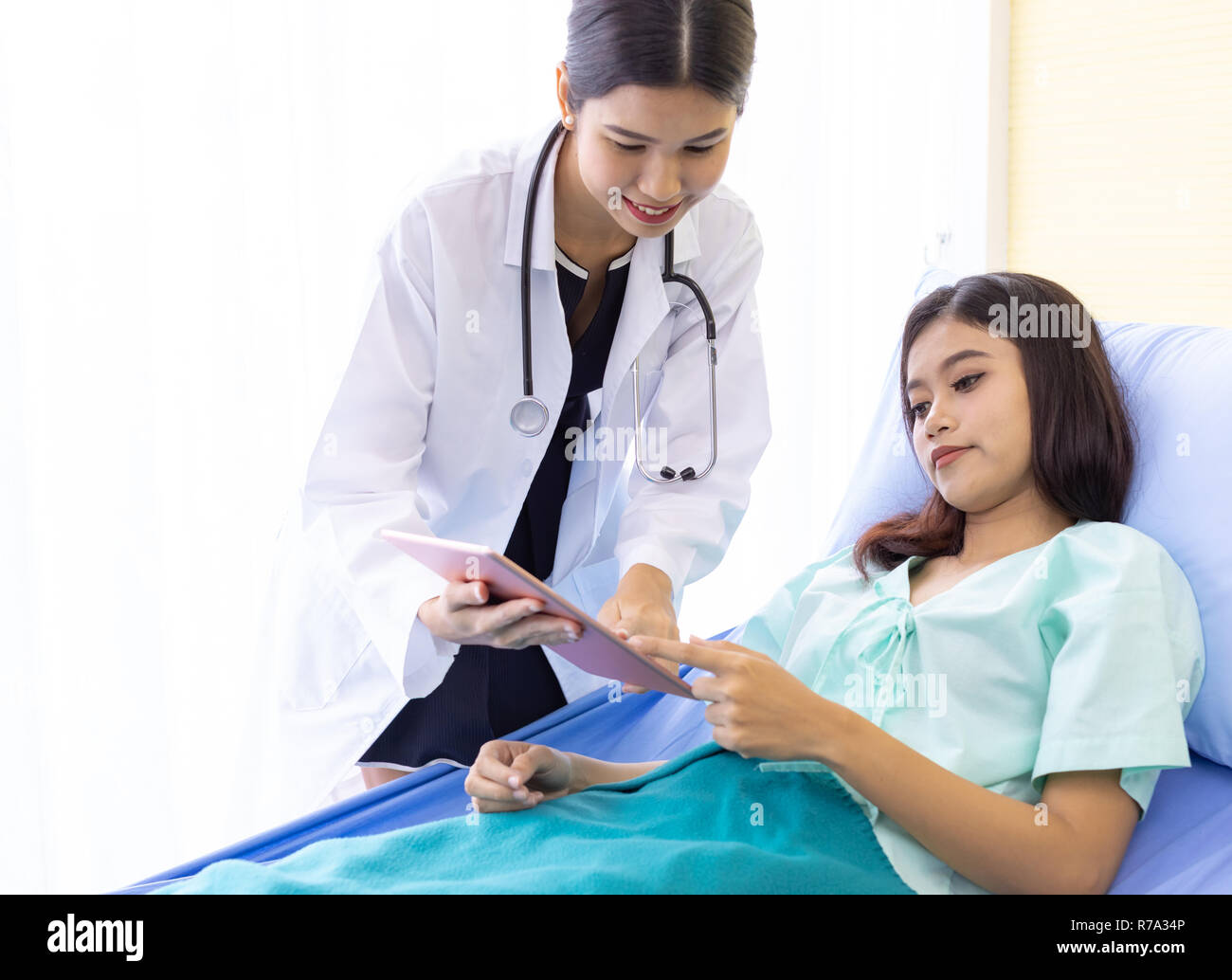 Asian Doctor make routine health check with patient in hospital ward ...