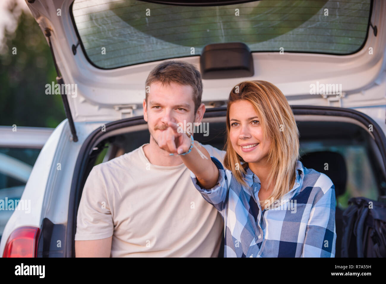 Young couple sitting on the back of a off road vehicle and enjoying the ...