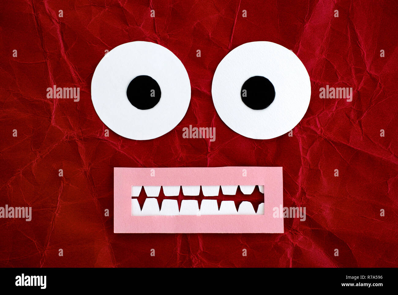 Scared emotional face made from paper. Red background Stock Photo - Alamy