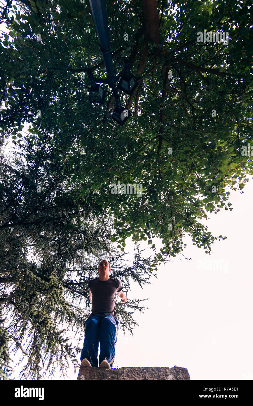 Young man in action while jumping on the wall Stock Photo - Alamy