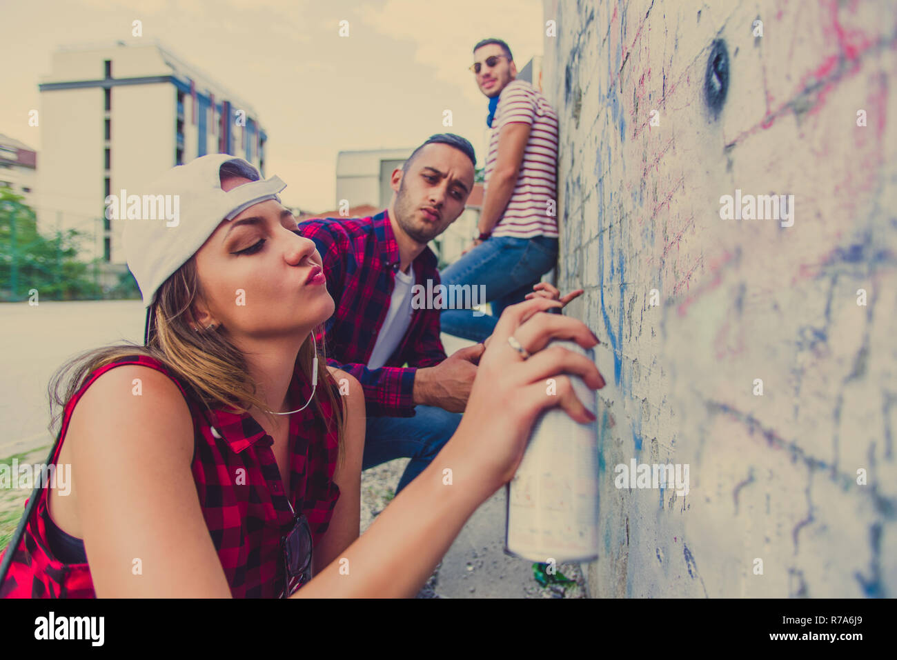 An urban people is writing black letters on old wall, having fun Stock ...