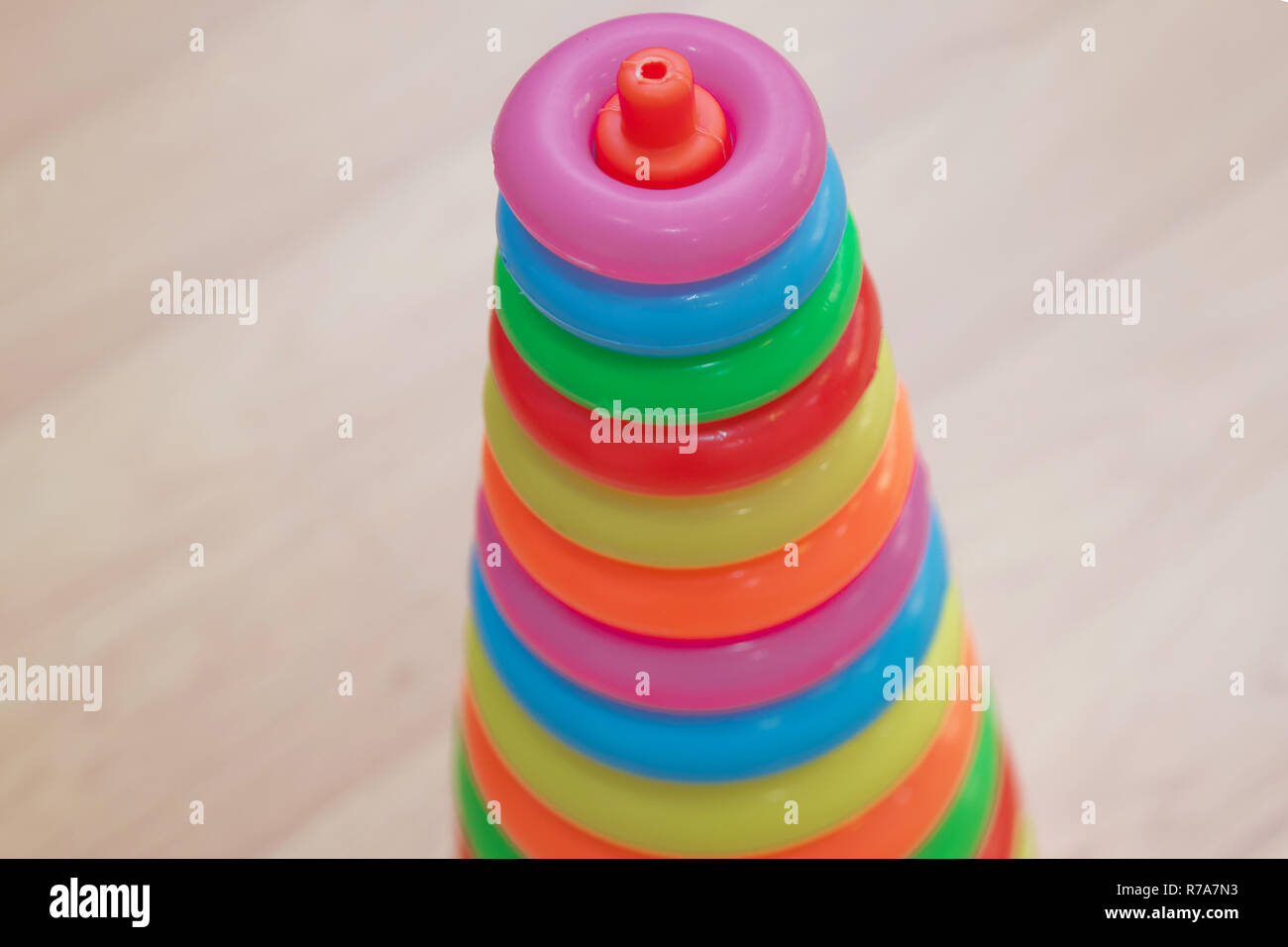 Pyramid build from colored wooden rings with a clown head on top. Toy ...