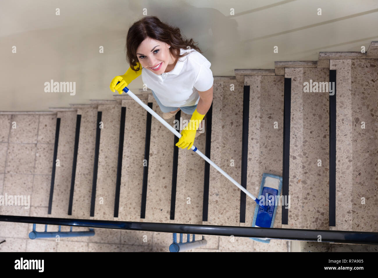 Young Female Janitor Cleaning Staircase With Mop Stock Photo - Alamy