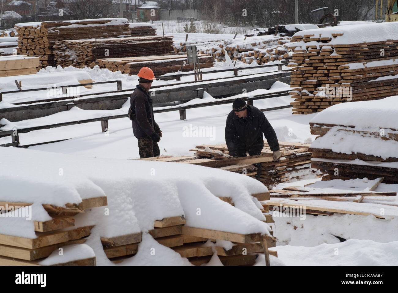 Woodpile stacked of firewood under the snow. Stack of cut wood under ...