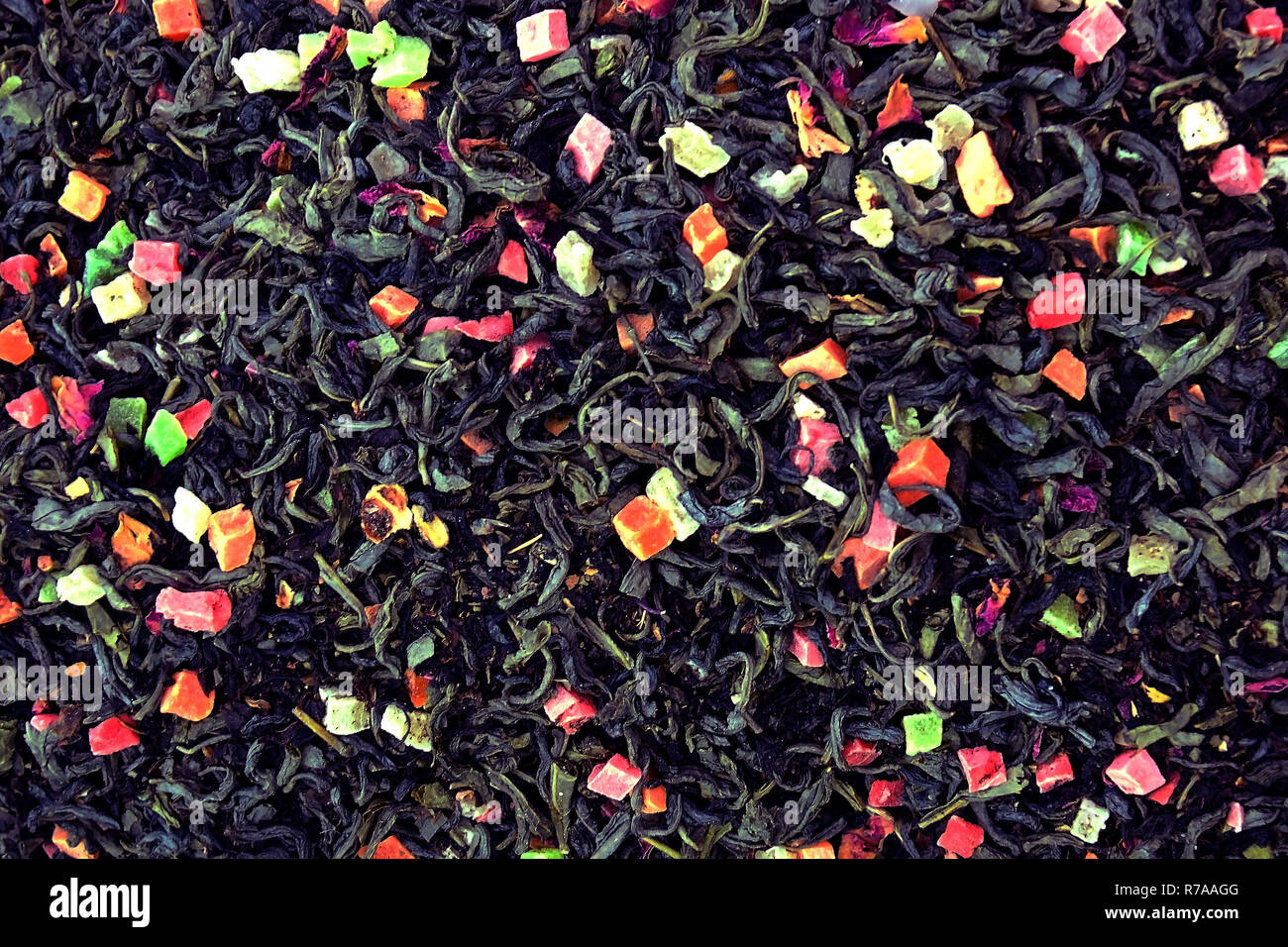 fruit black tea with flowers. background of dry tea, top view closeup ...