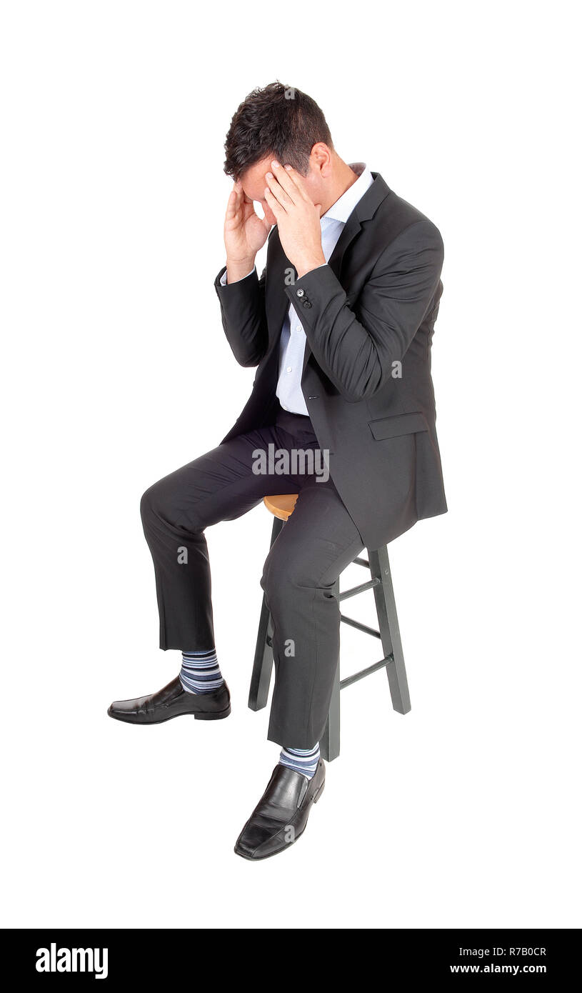 Suffering man sitting and holding hands over face Stock Photo - Alamy