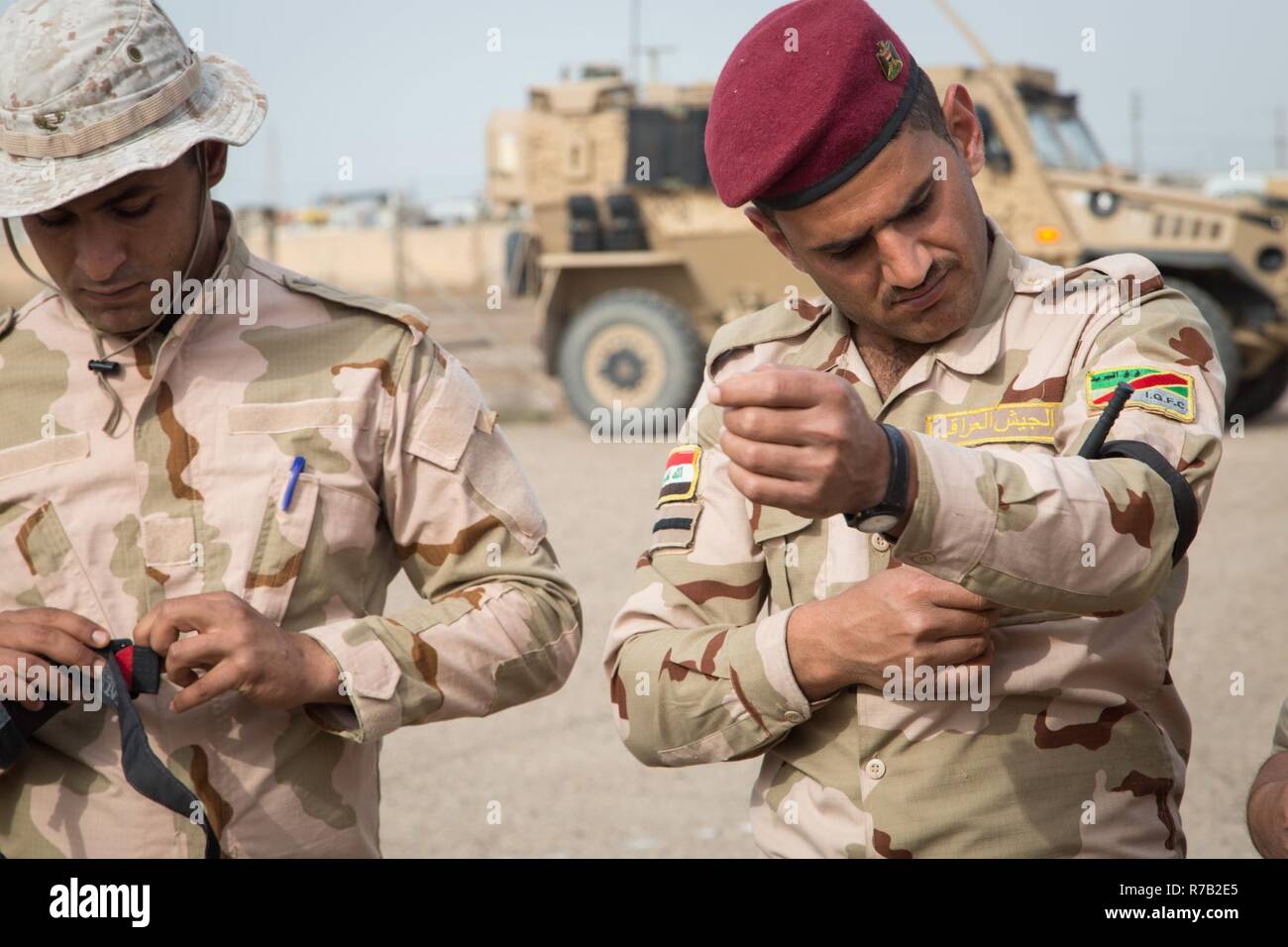 An Iraqi security forces soldier applies a tourniquet to himself during ...
