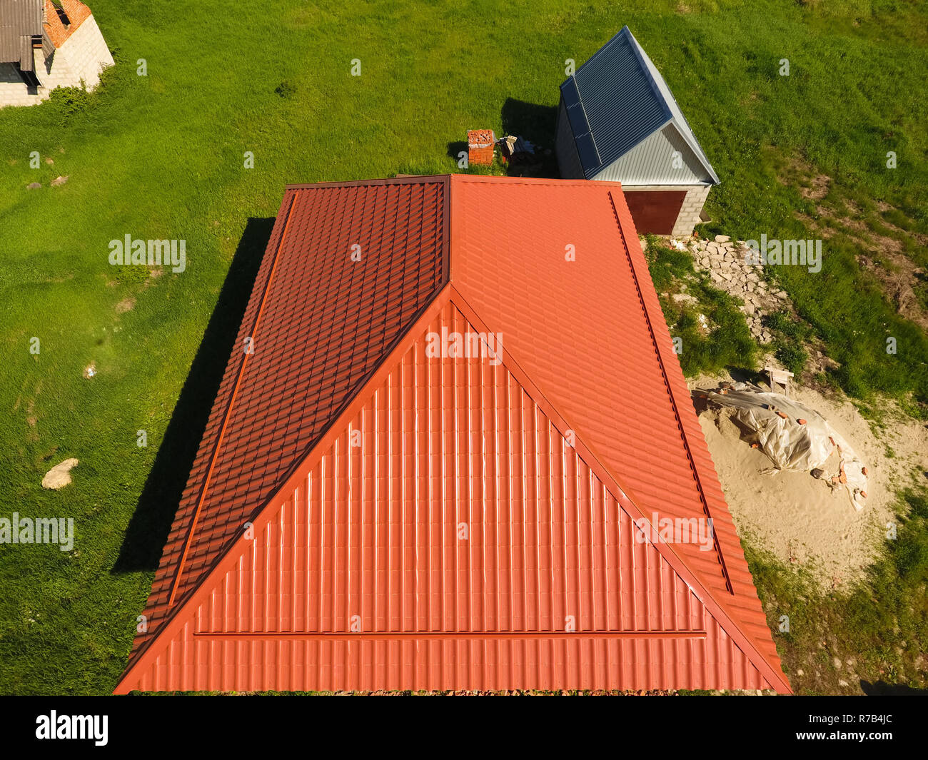 House with an orange roof made of metal, top view. Metallic profile ...