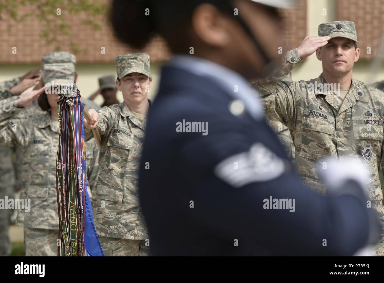Airmen from the 32nd Intelligence Squadron salute as the U.S. flag is lowered during an annual ...