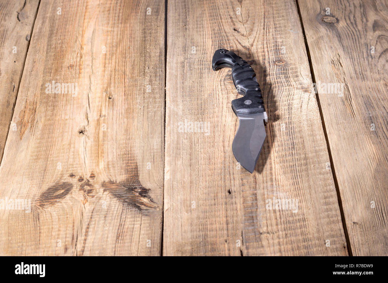 Large folding knife on a wooden background. A massive knife on the ...