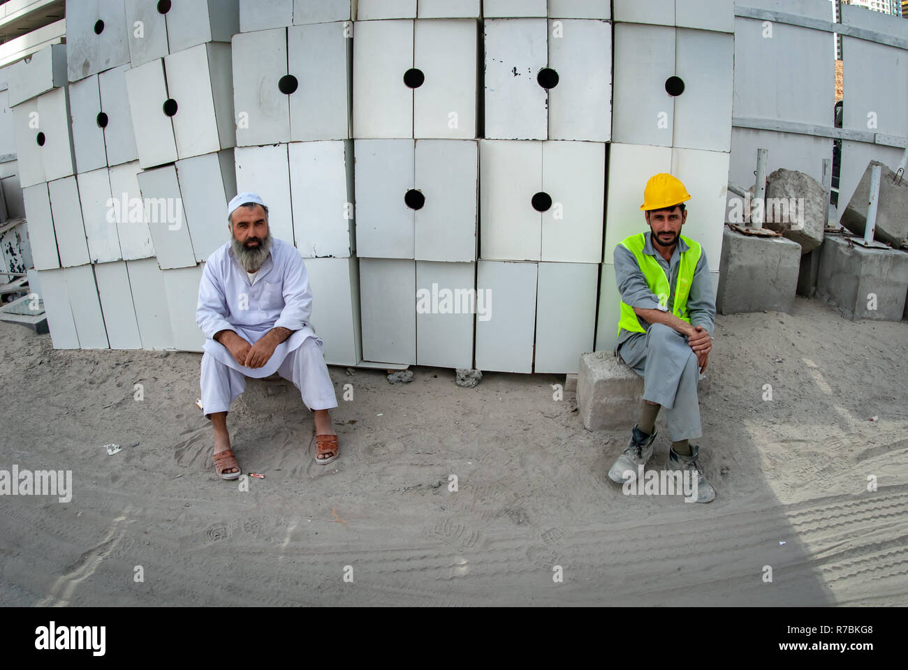 Two building Workers relaxing at a building site in Dubai, UAE Stock ...