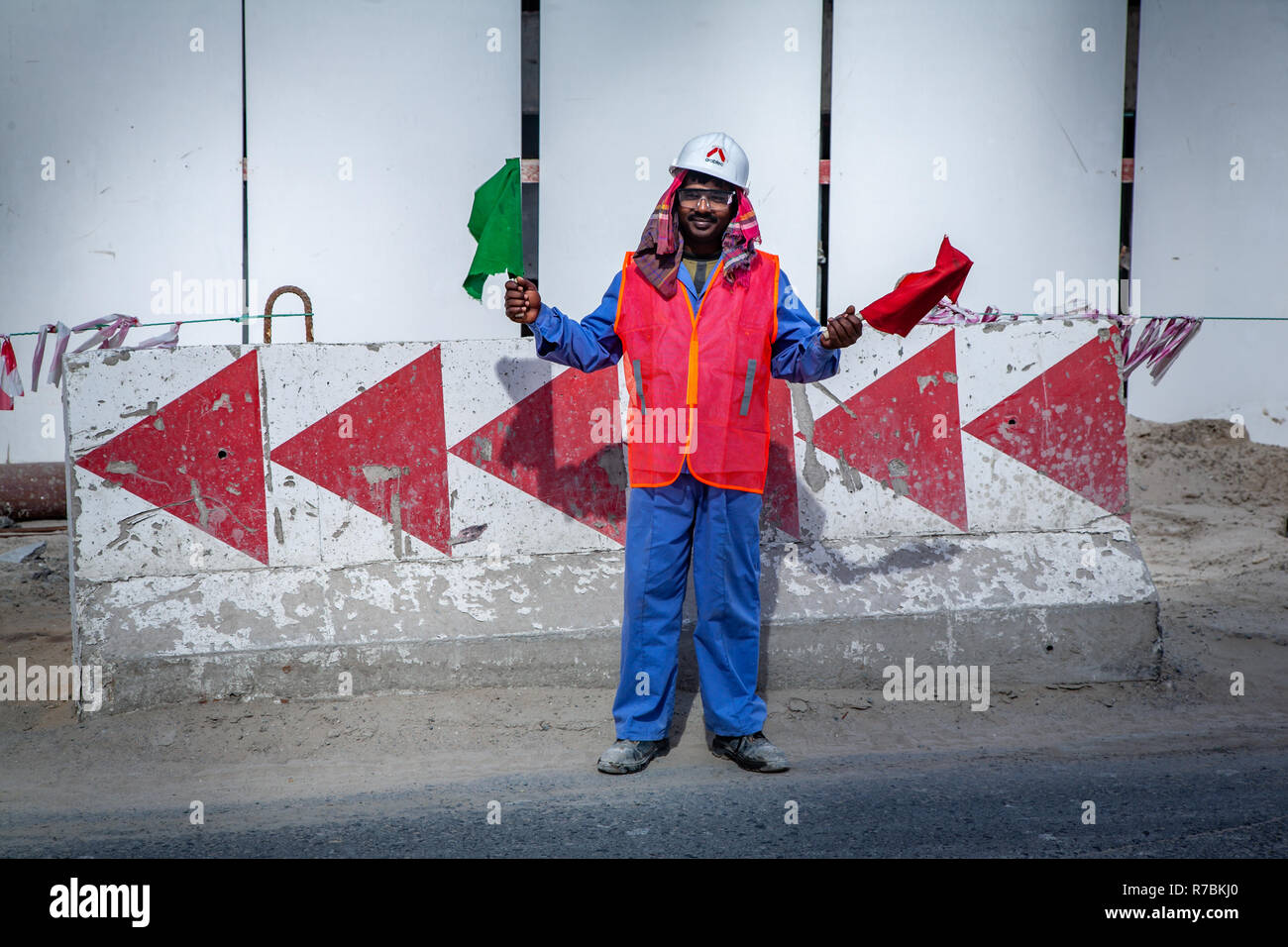 Construction site traffic controller waves flags on building site in ...