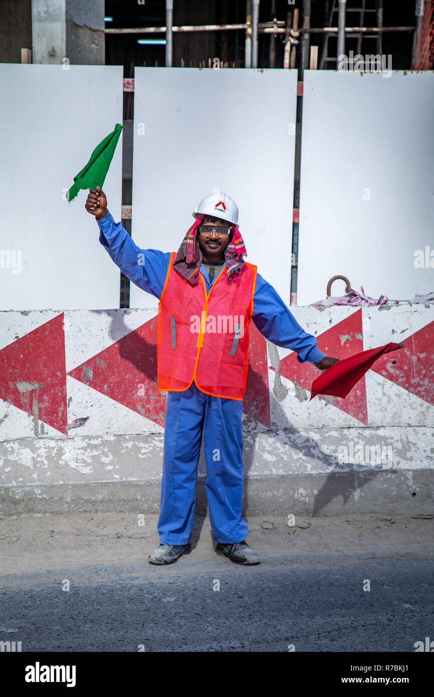 Construction site traffic controller waves flags on building site in ...