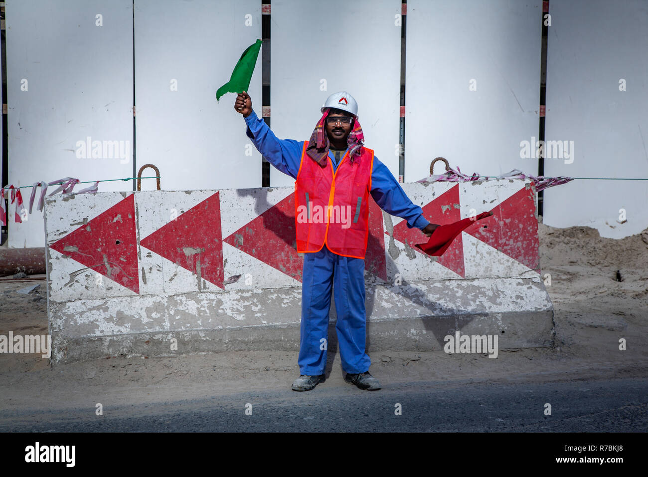 Construction site traffic controller waves flags on building site in ...