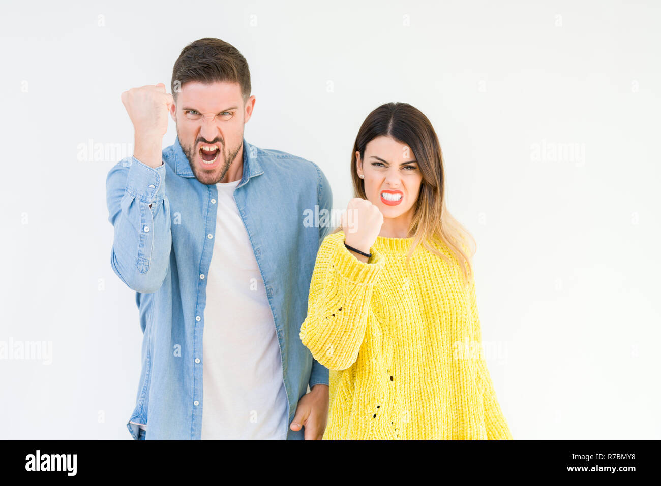 Young beautiful couple togheter over isolated background angry and mad ...