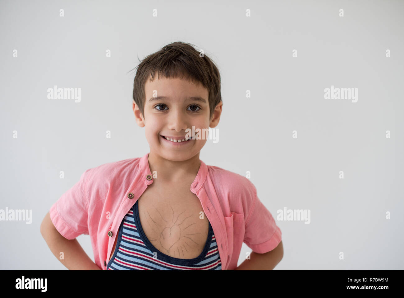 happy little boy looking at heart love symbol sketched on his chest ...