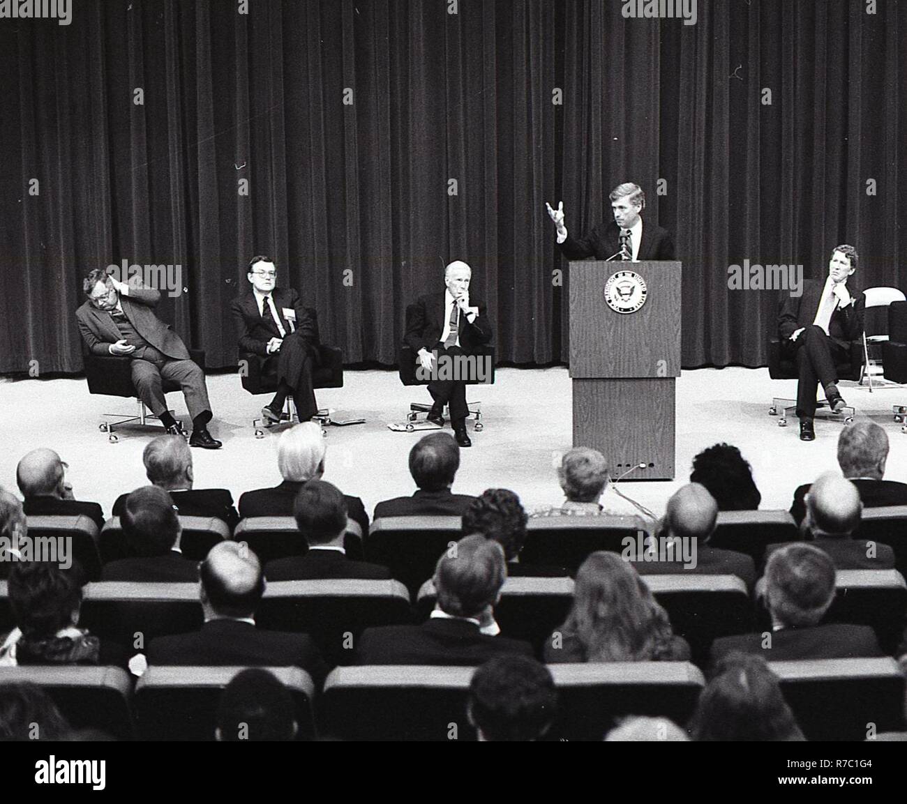 THERE IS A MAN AT THE PODIUM GIVING A SPEECH WITH HIS HANDS IN THE AIR ...