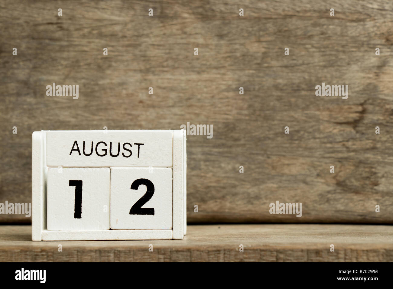 White block calendar present date 12 and month August on wood ...