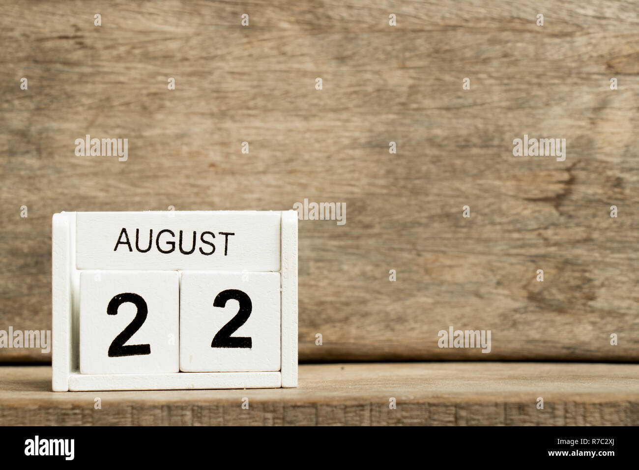 White block calendar present date 22 and month August on wood ...