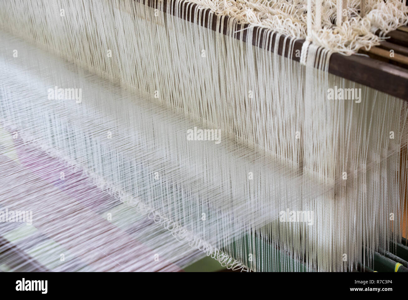 Closed up of loom with white thread background Stock Photo - Alamy