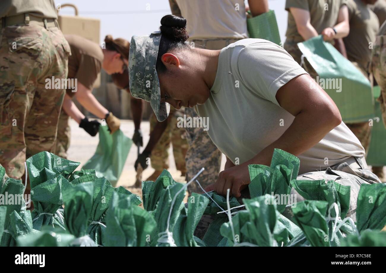 Soldiers with U.S. Army Central fill sandbags in the early stages of ...