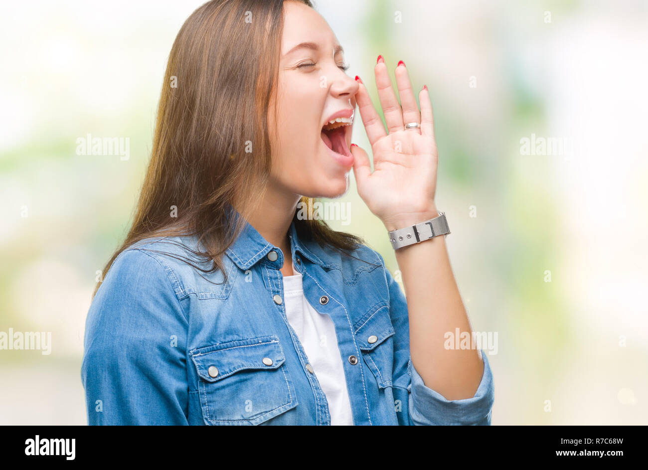 Young caucasian beautiful woman over isolated background shouting and ...