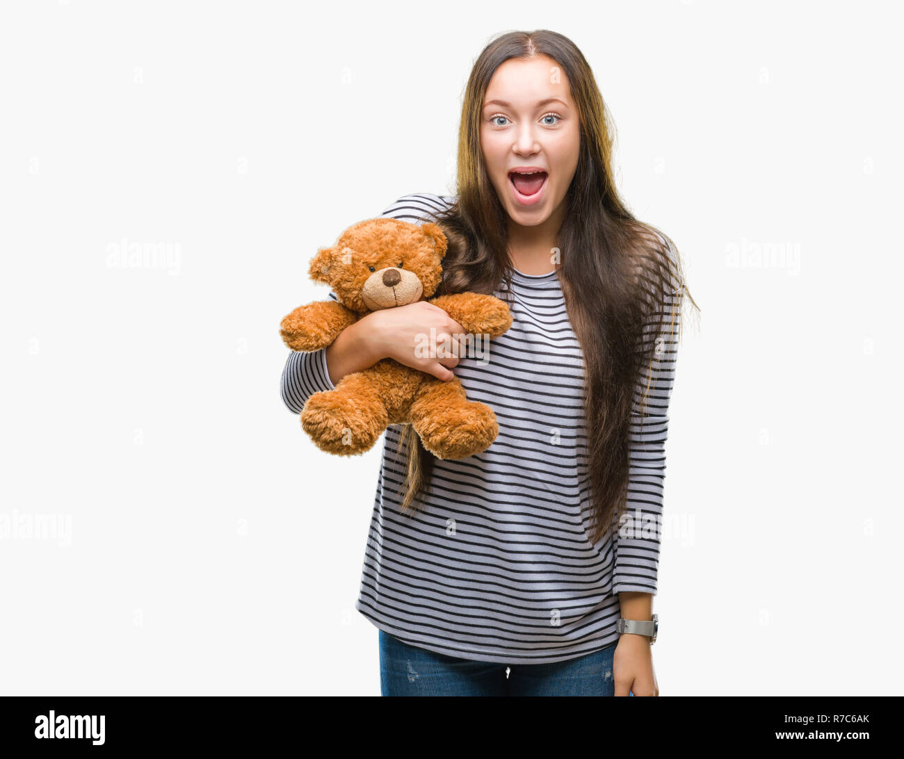 Young caucasian woman holding teddy bear over isolated background ...