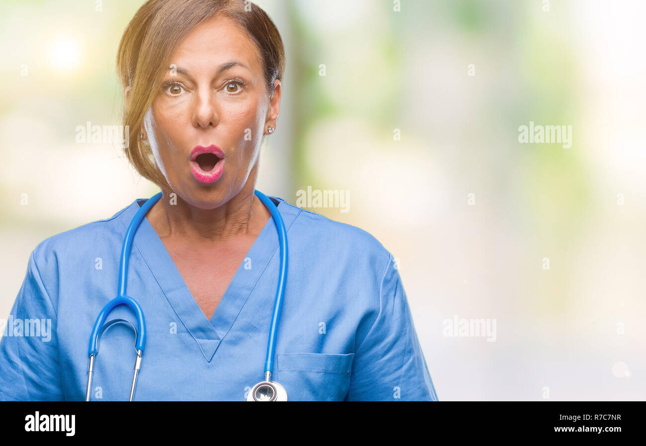 Middle age senior nurse doctor woman over isolated background afraid ...