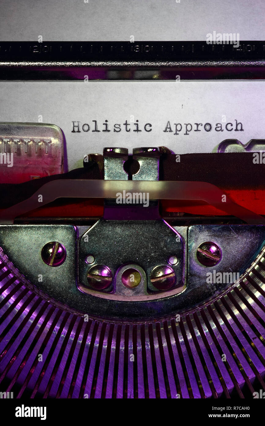 Vintage typewriter with the phrase holistic approach printed on a ...