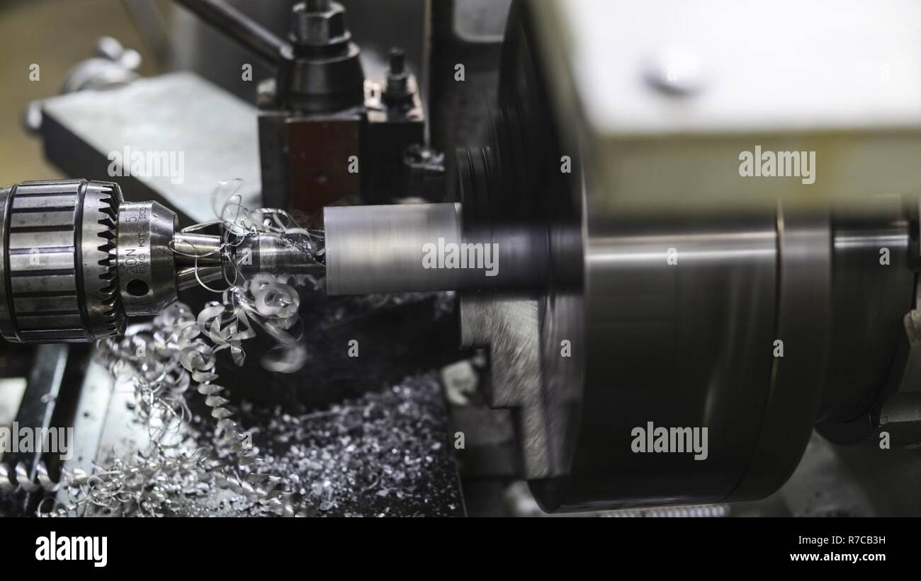 A lathe is used to drill a centered hole during the fabrication an ...