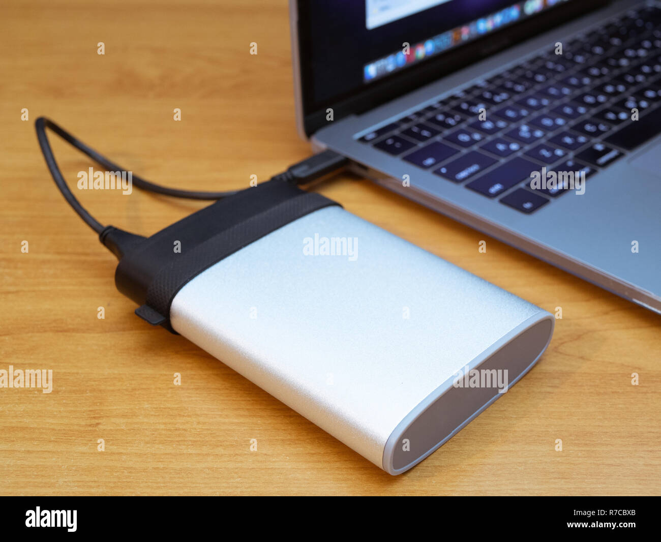 portable external disk drive connected to laptop by wire. data backup ...
