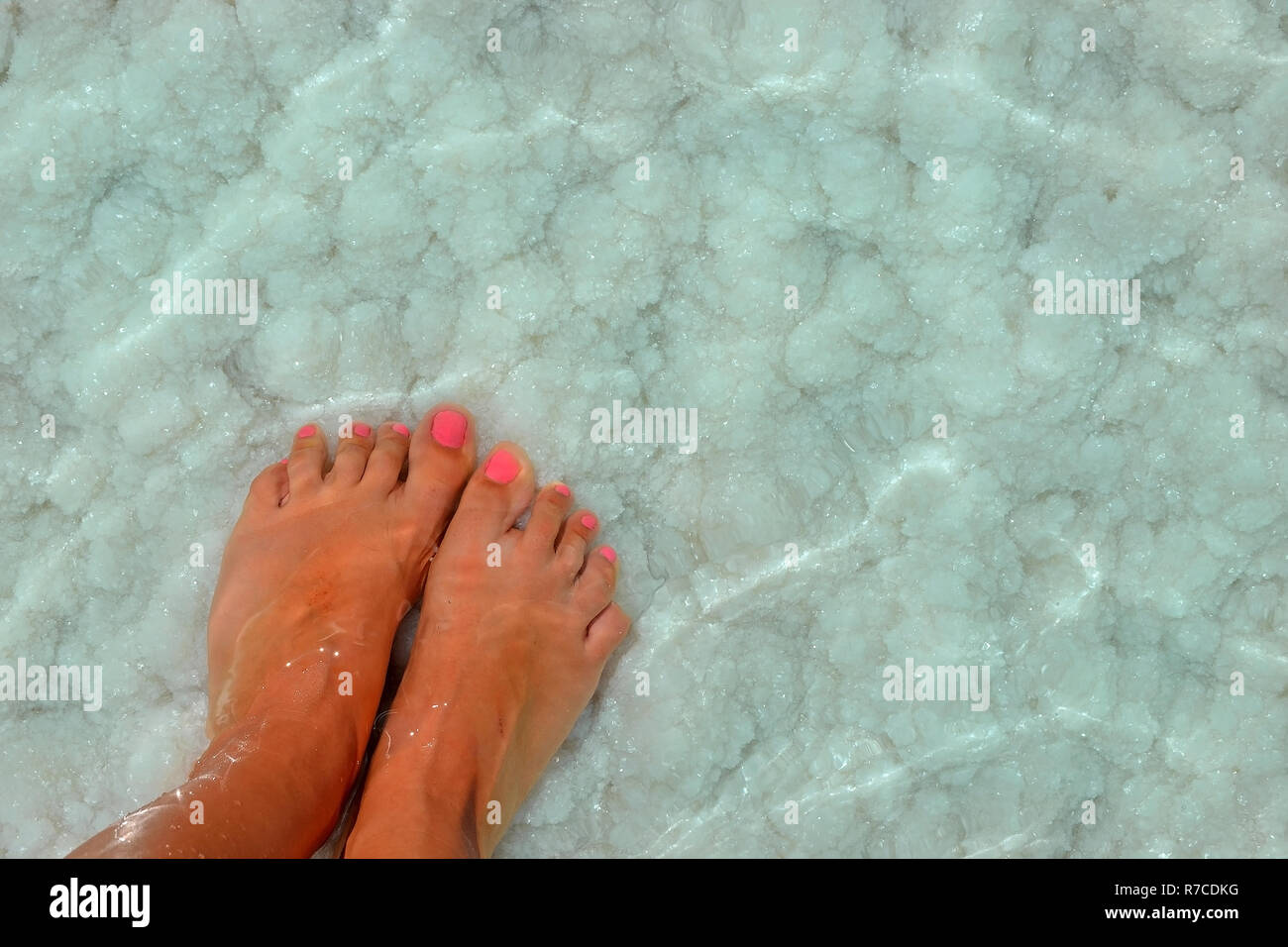 Female feet with manicure on stone, covered with salt formations ...