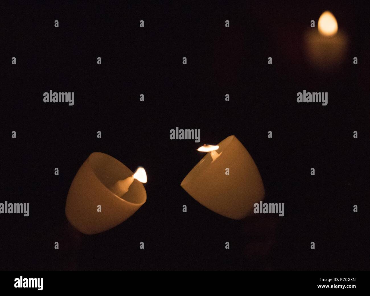 The flames of candles light up the dark during the 29th Annual ...