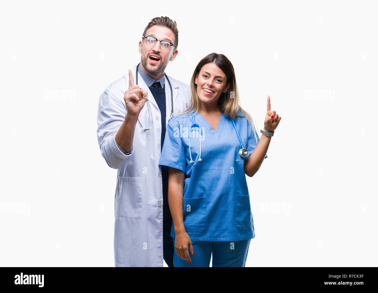 Young couple of doctor and surgeon over isolated background pointing ...