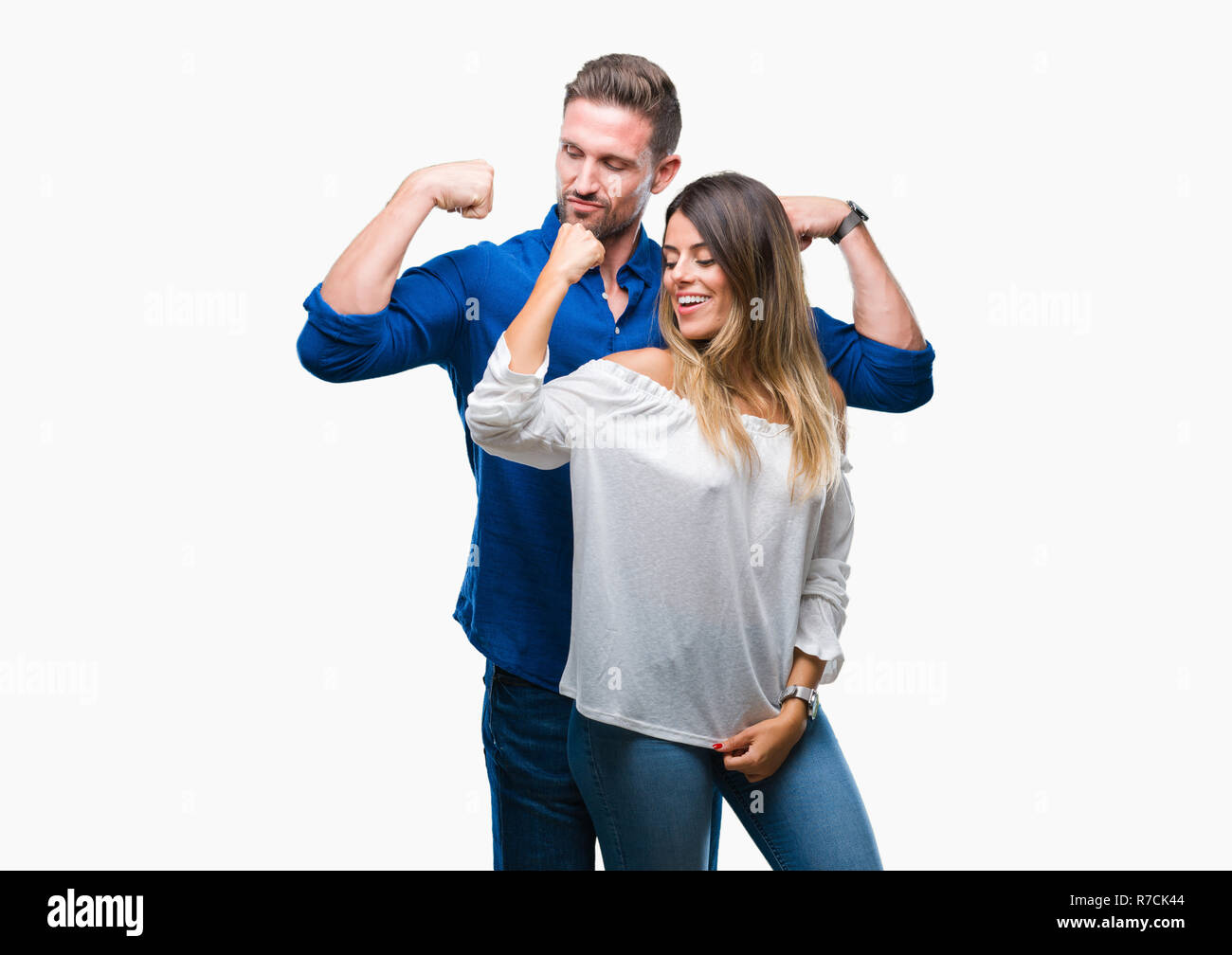 Young couple in love over isolated background showing arms muscles ...