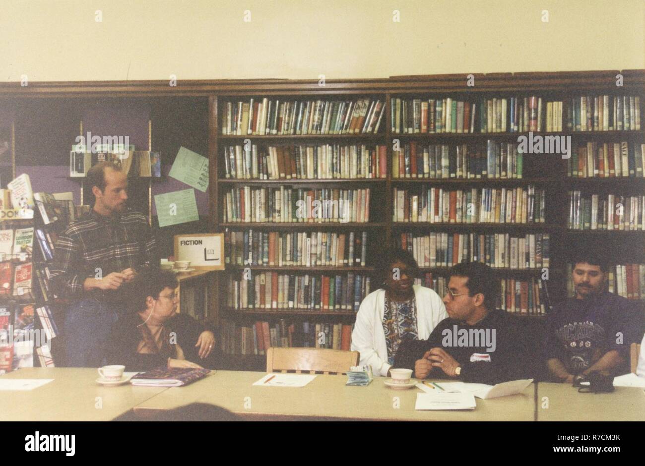 A GROUP OF MEN AND WOMEN ARE HAVING A CONVERSATION IN THE LIBRARY Stock ...