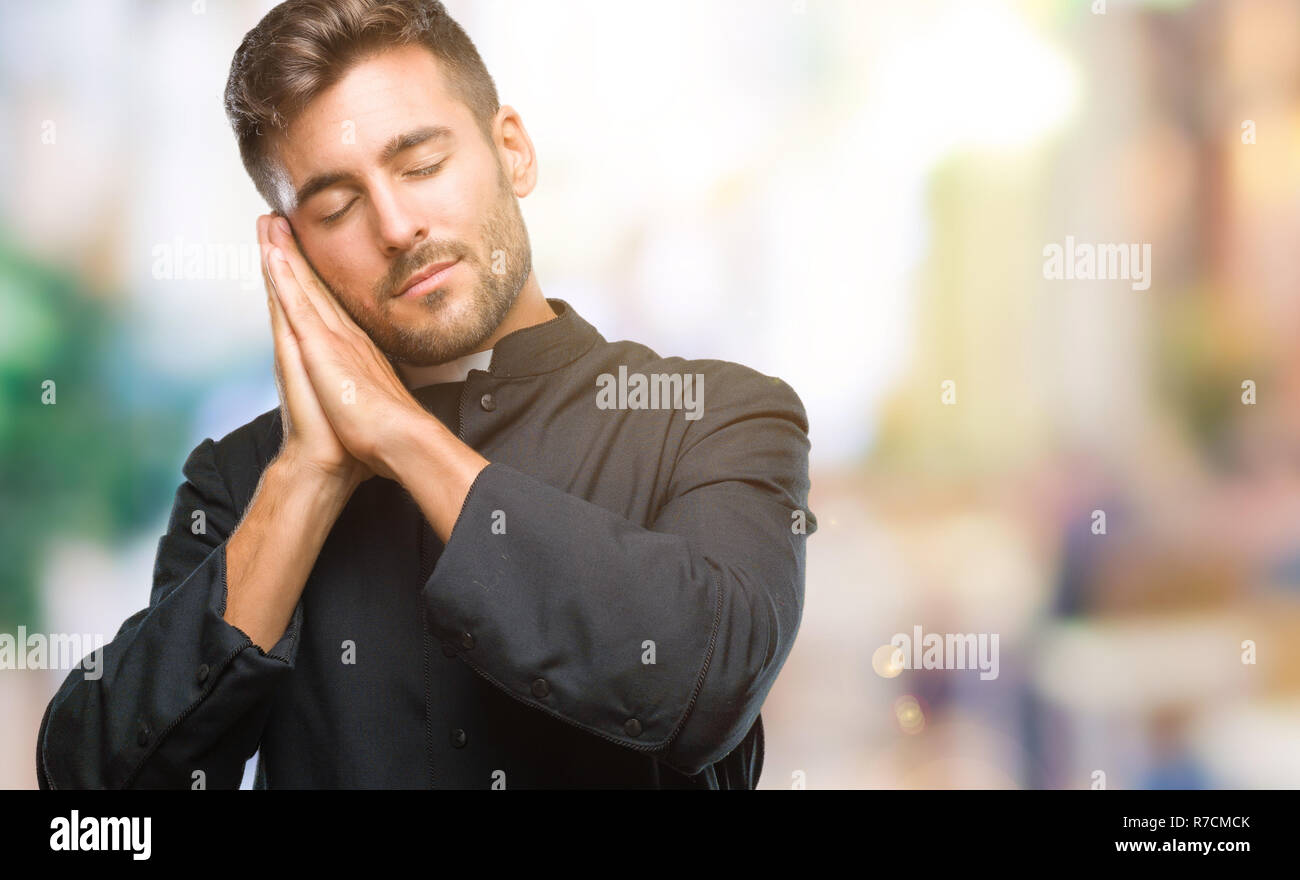 Young catholic christian priest man over isolated background sleeping ...