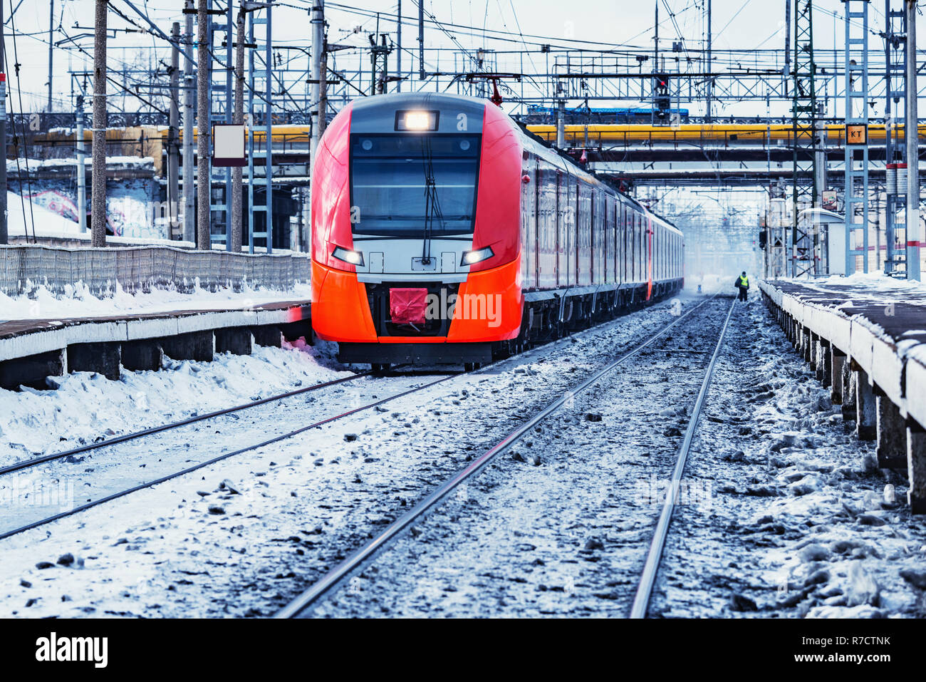 Modern high-speed train approaches to the station at winter morning ...