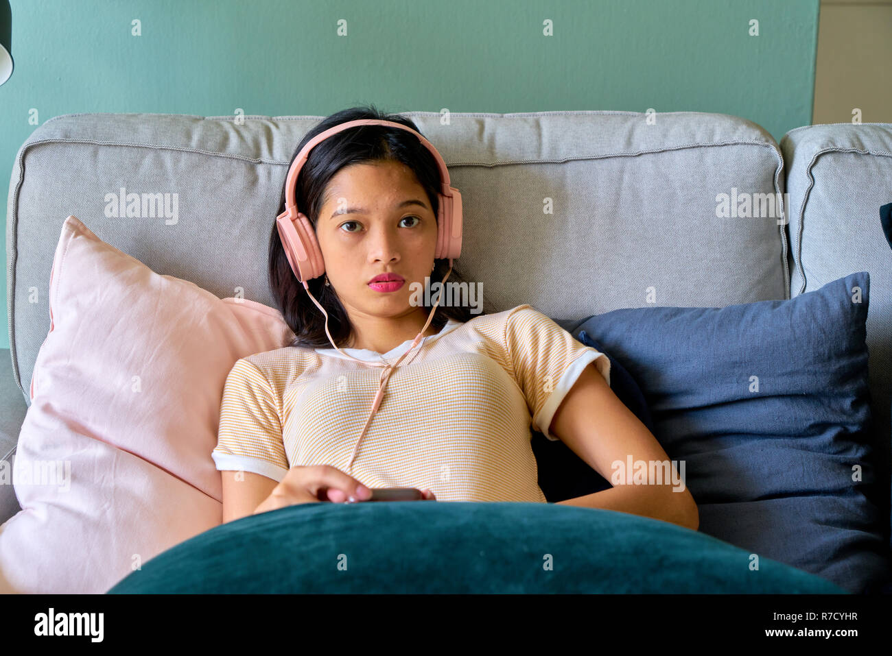 Beautiful woman posing - lying down, listening music, serious and ...