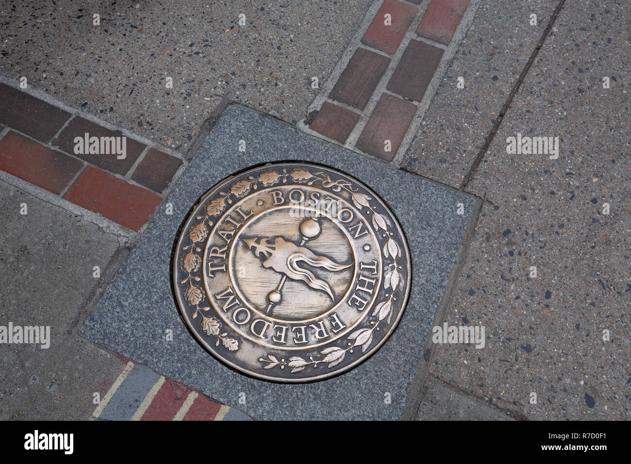 A brick line and brass medallion in the pavement marking the historic ...