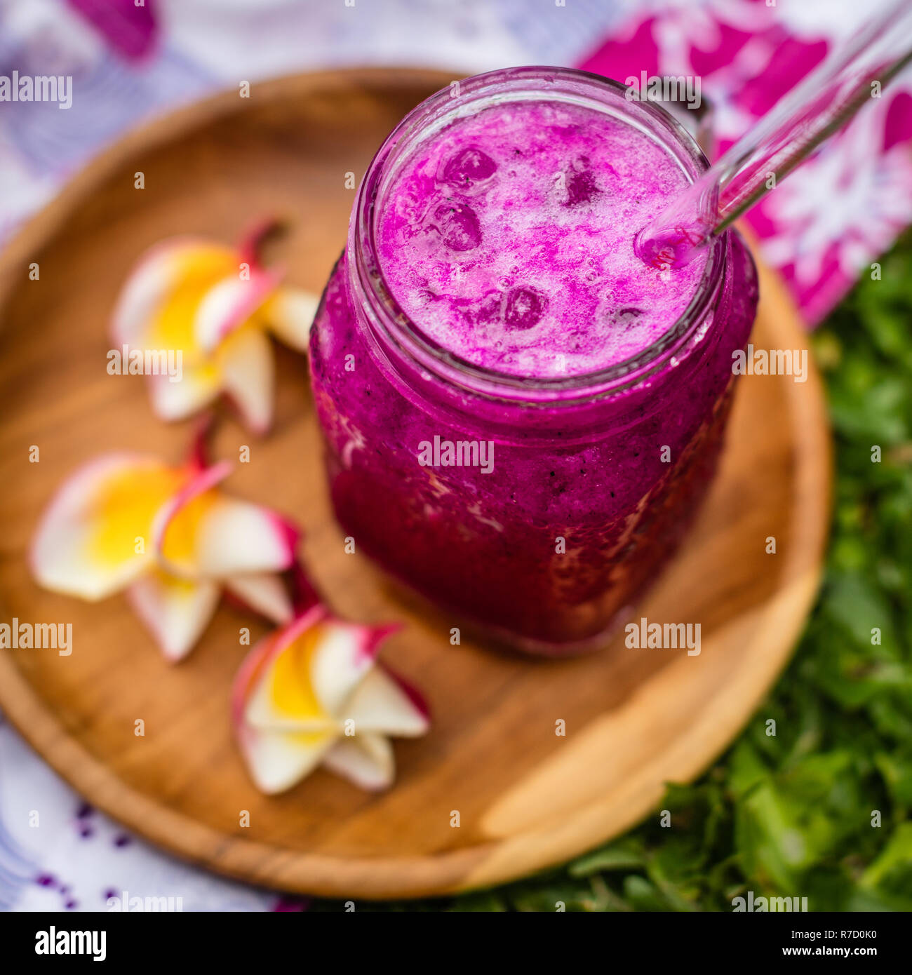 Red Dragon fruit juice in a glass full of ice with glass straw, on a ...