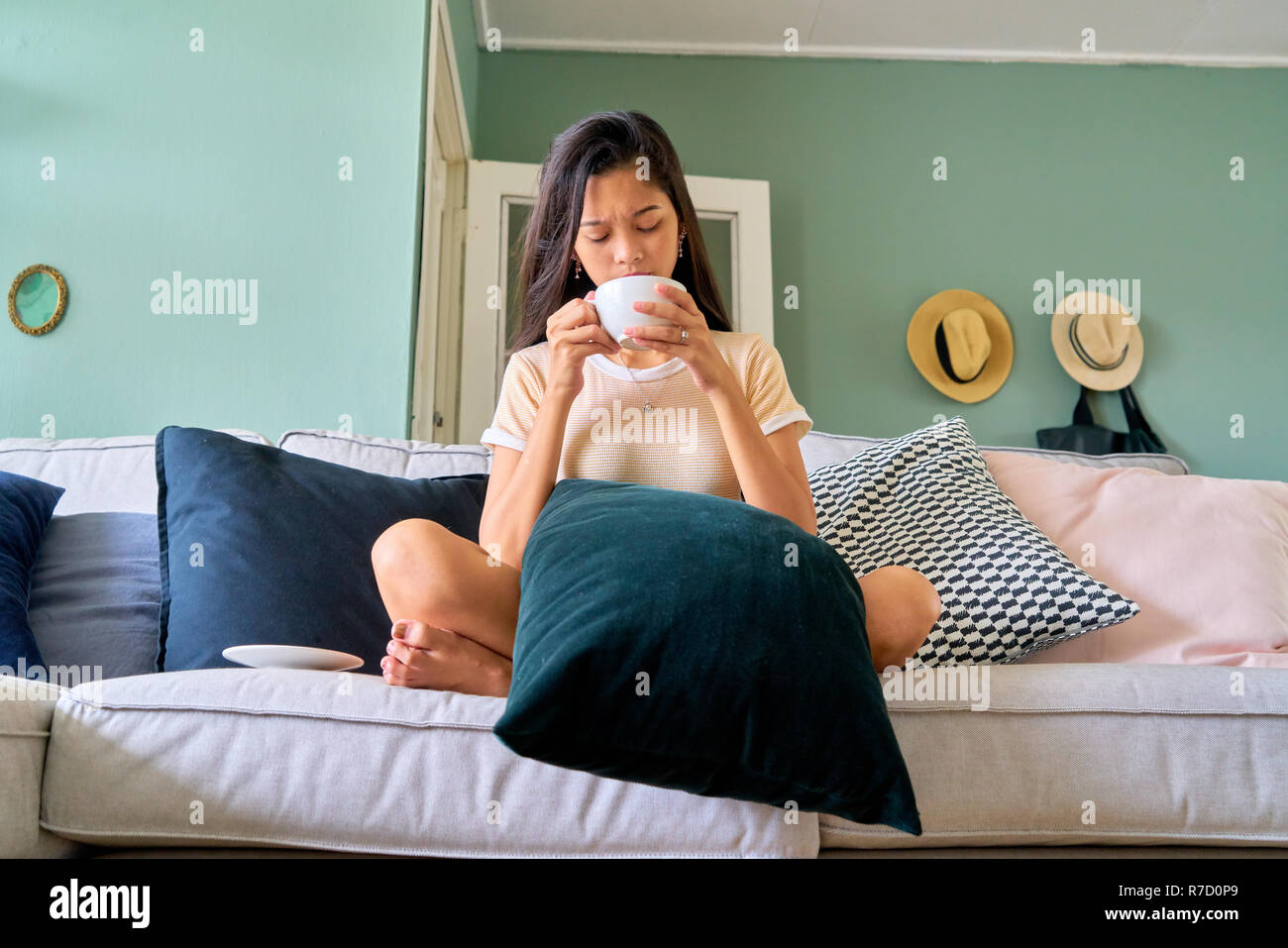 Beautiful woman posing - sitting, drinking coffee, disgust and unhappy ...