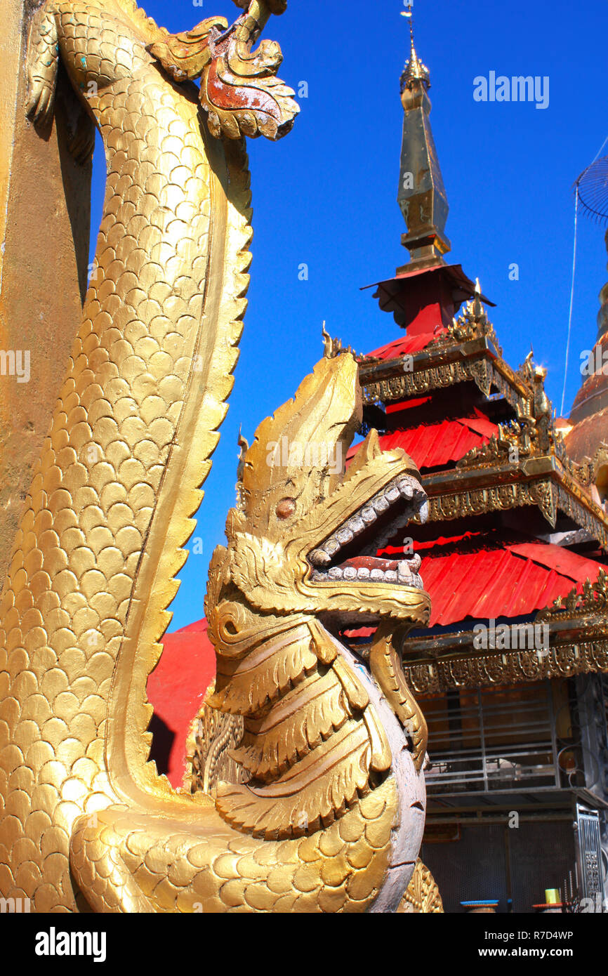 Ancient golden dragon in traditional burmese style and roof of temple ...