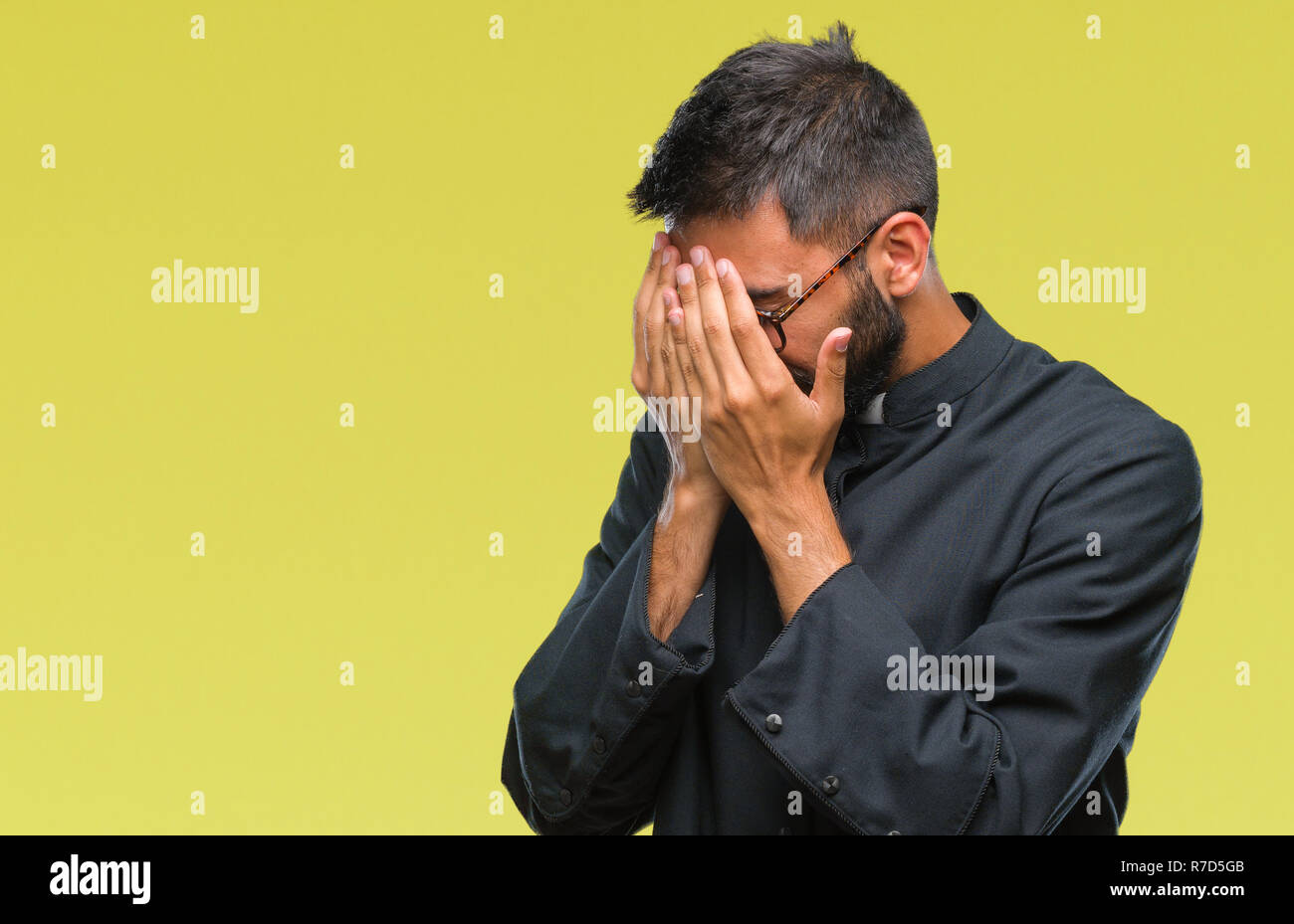 Adult hispanic catholic priest man over isolated background with sad ...