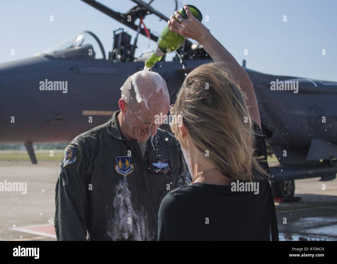 Jennifer Azzano, pours a celebratory bottle of champagne on her husband ...