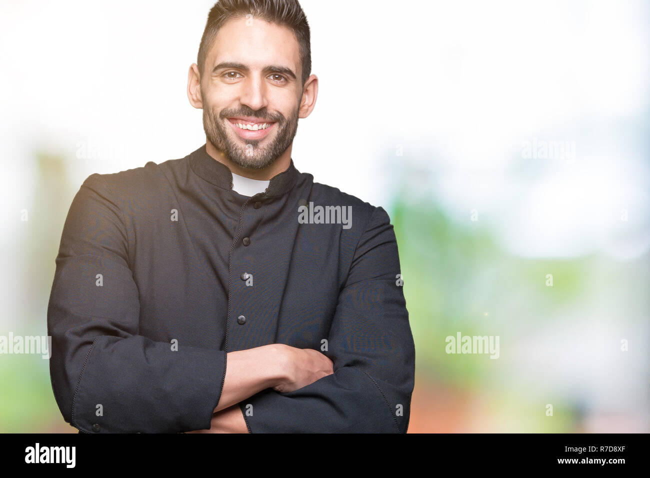 Young Christian priest over isolated background happy face smiling with ...
