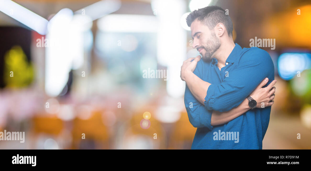 Young handsome man over isolated background Hugging oneself happy and ...