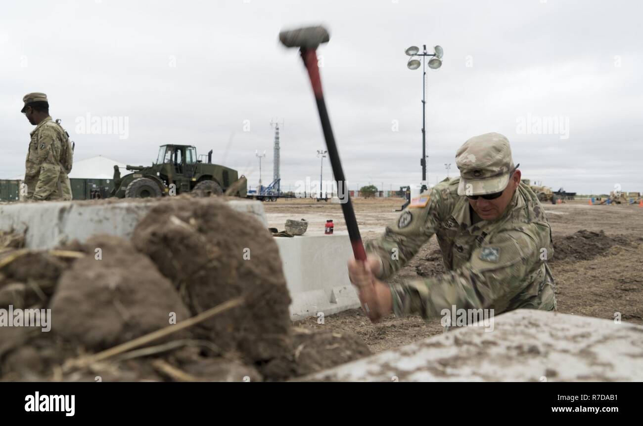 An Army engineer from the 19th Engineer Battalion hammers a post for a ...